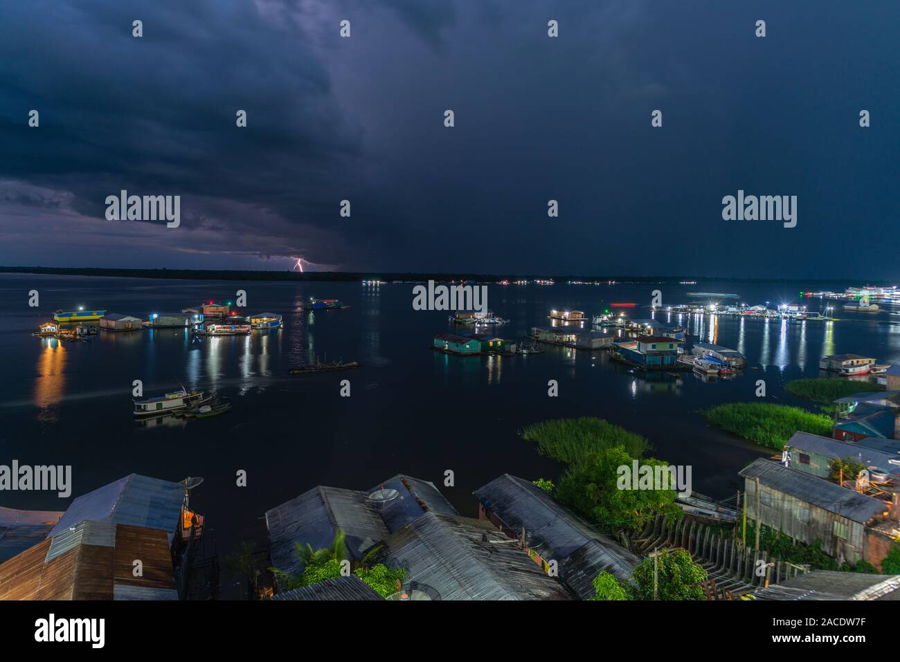 Flash and lightning over the swimming houses on Lake Tefé, small town ...