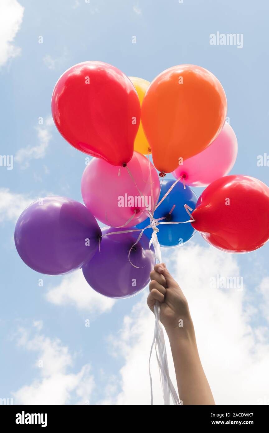 Girl's hand holding balloons Stock Photo - Alamy
