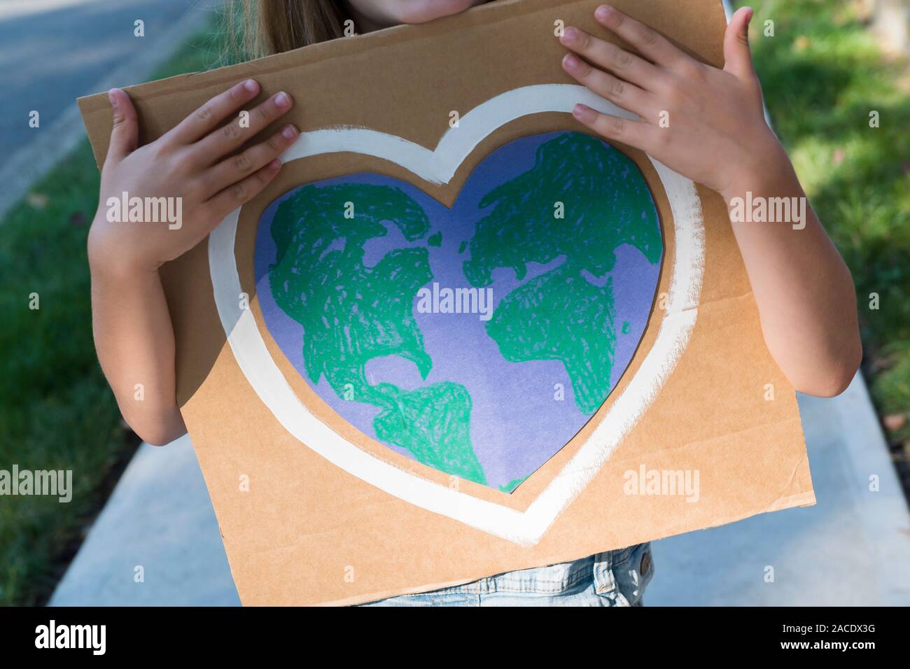 Young environmental activist holding sign Stock Photo - Alamy
