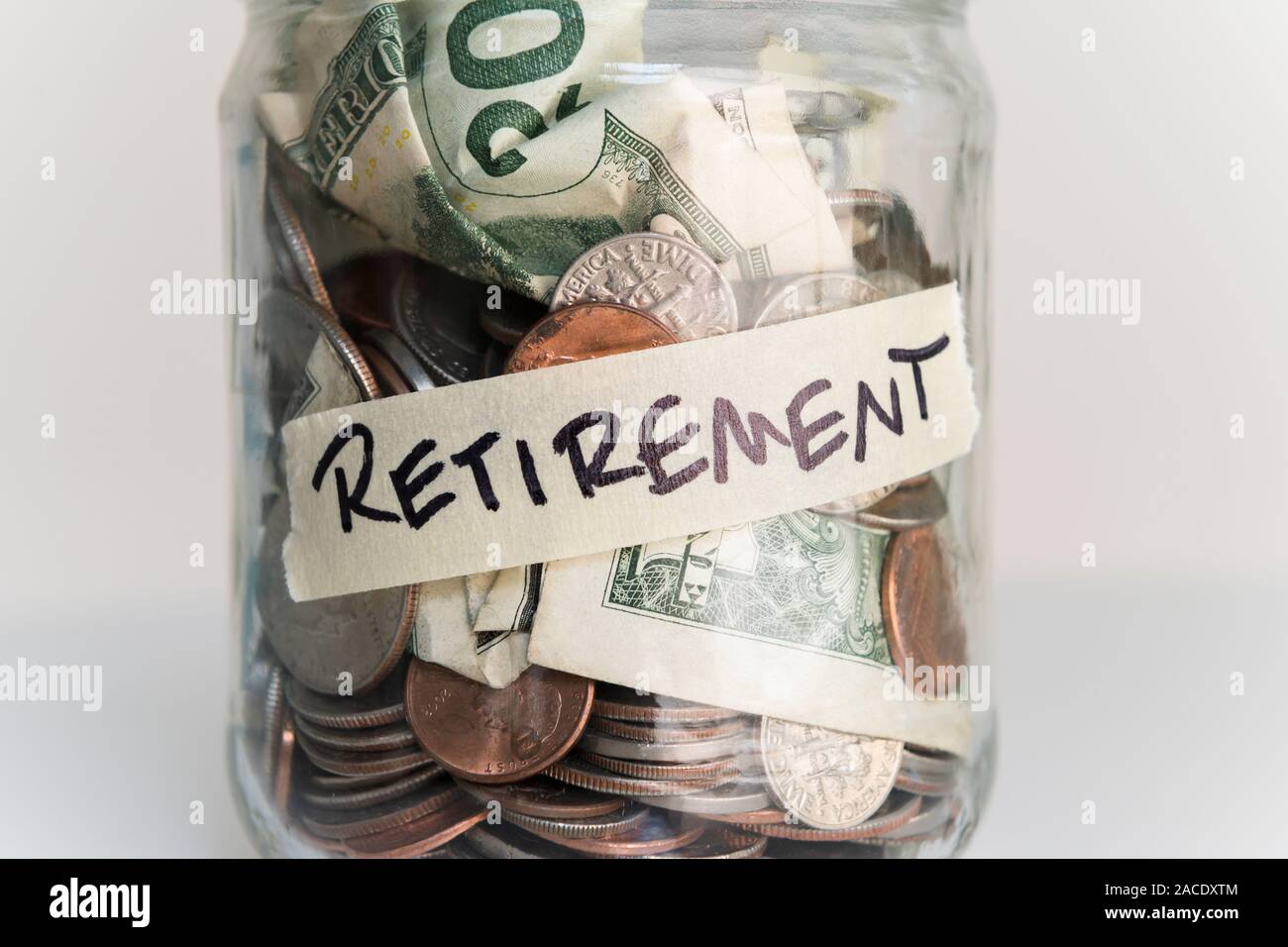 Money in jar labeled 'retirement' Stock Photo - Alamy