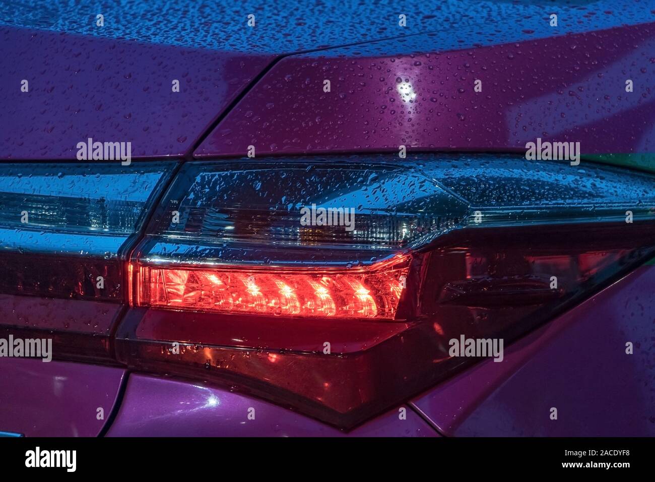 Close-up view of illuminating car rear light. Tail light with hood ...