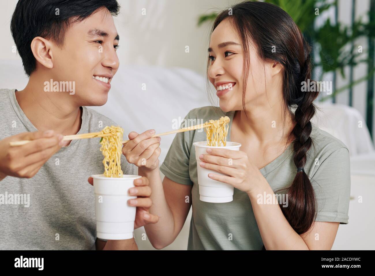 College students eating instant noodle from plastic cups with ...