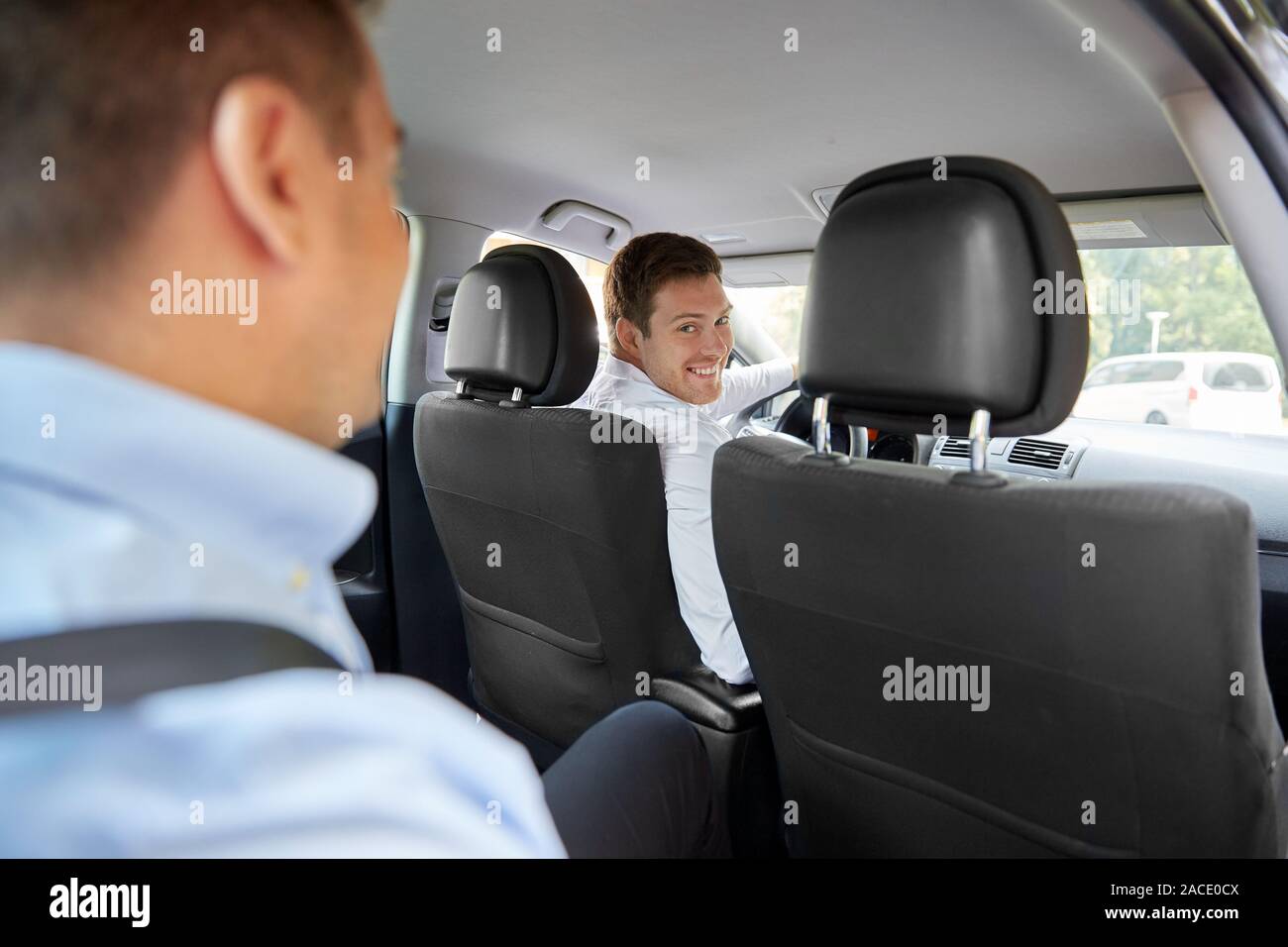 male driver driving car with passenger Stock Photo - Alamy
