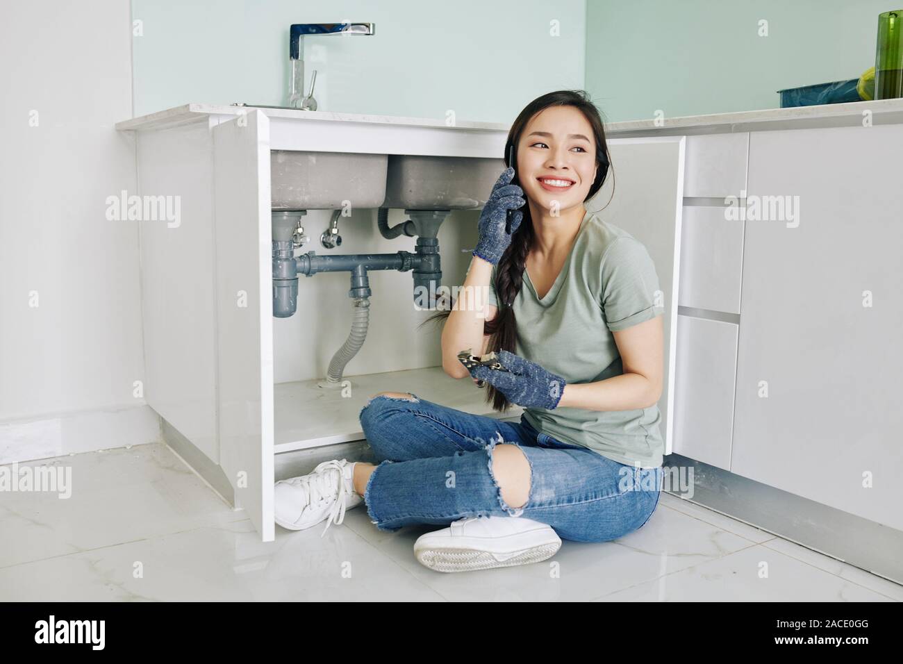 Female plumber fixing sink hi-res stock photography and images - Alamy