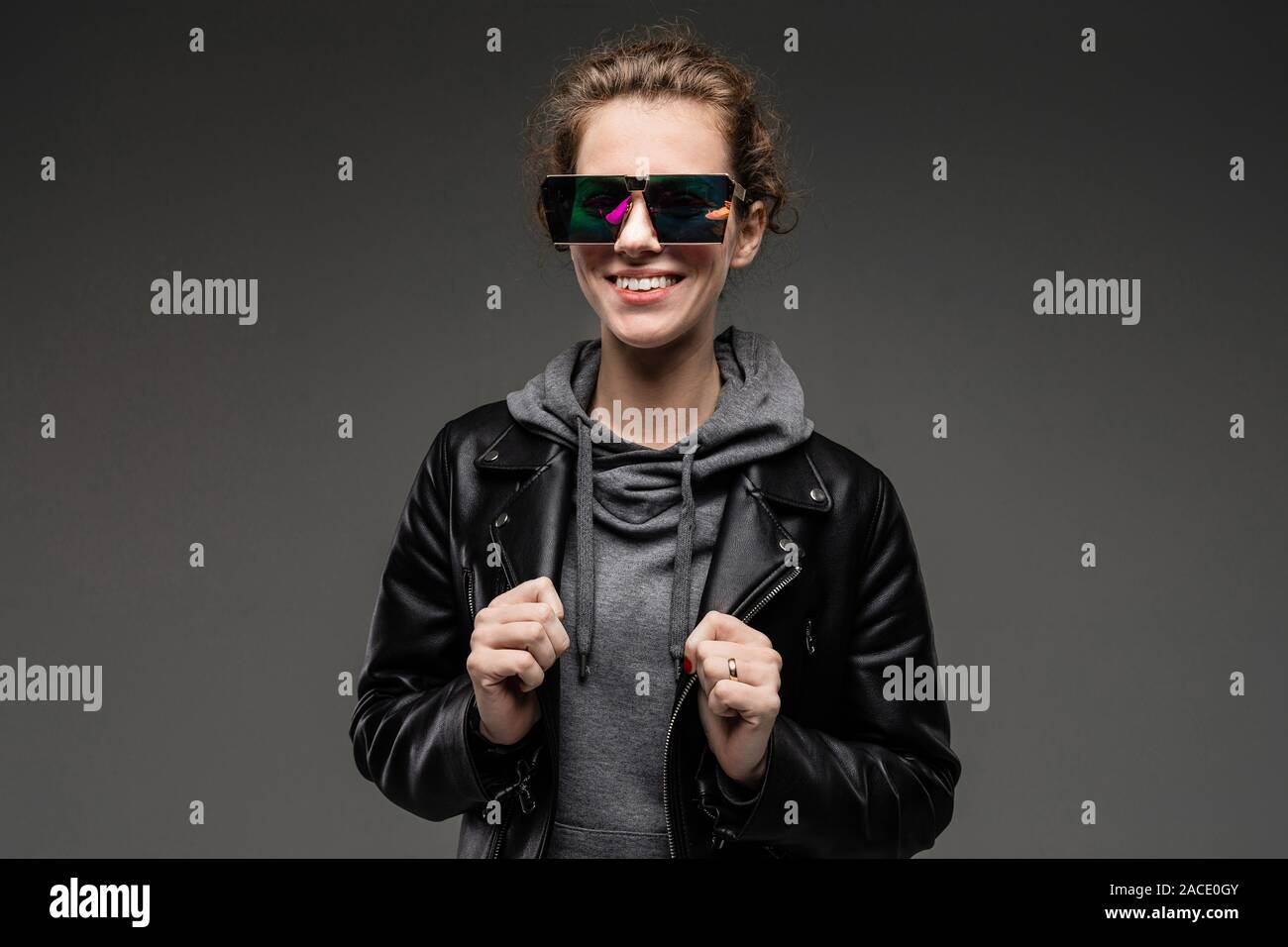 A young girl with rough facial features in a black jacket isolated on ...