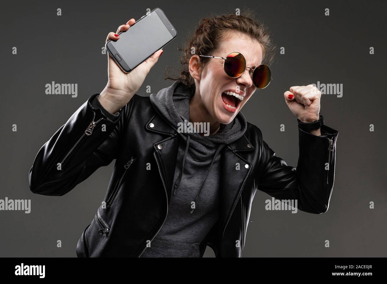 Stubborn caucasian girl with rough facial features in a black jacket ...