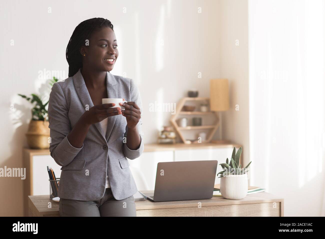 Black female employee drinking coffee in office, having break in work ...