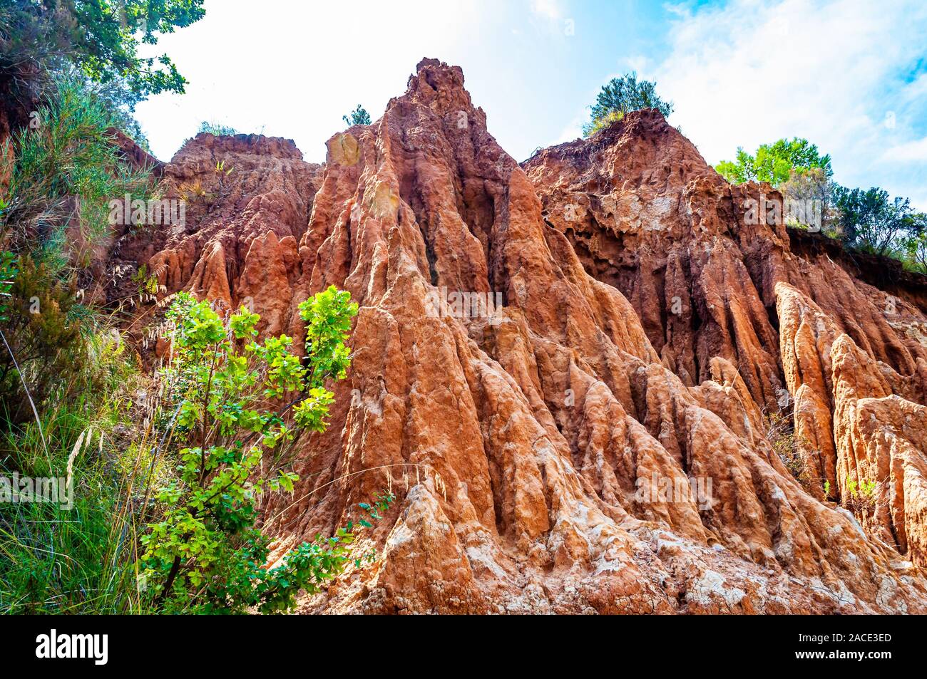 High red clay rocks and cliffs washed by winter rains and surface water ...