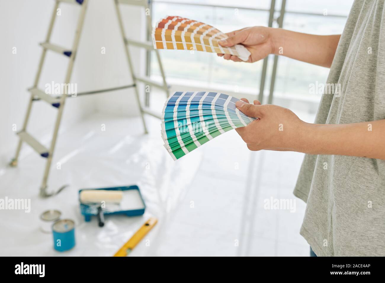 Paper palletes of paint swatches in hands of person choosing color for ...