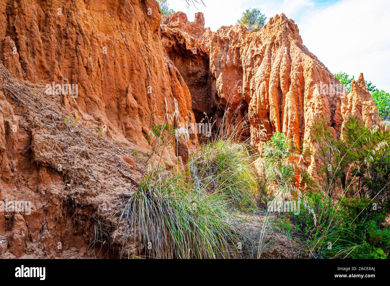 High red clay rocks and cliffs washed by winter rains and surface water ...