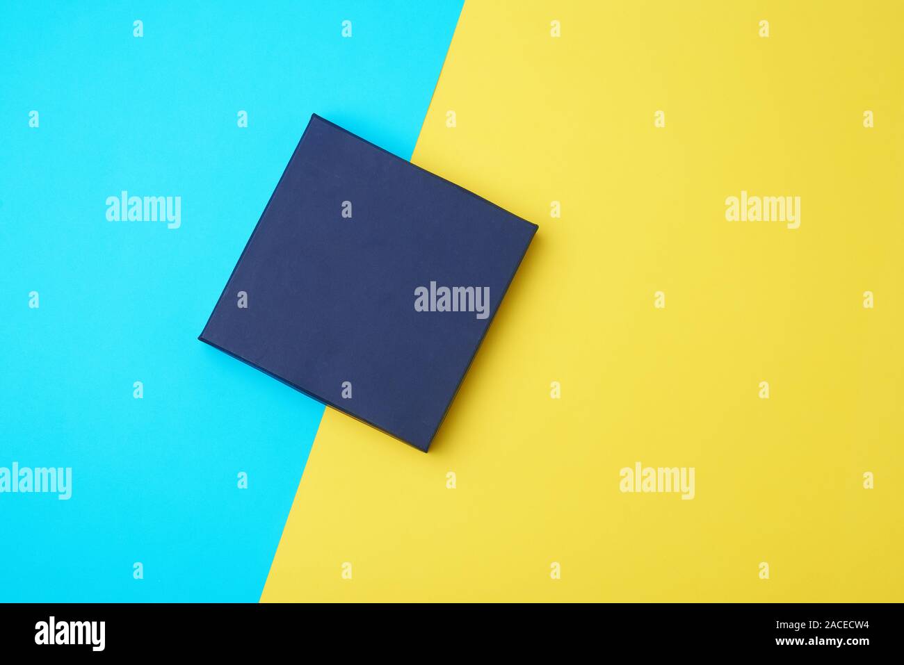 closed dark blue paper cardboard box on a yellow-blue background ...