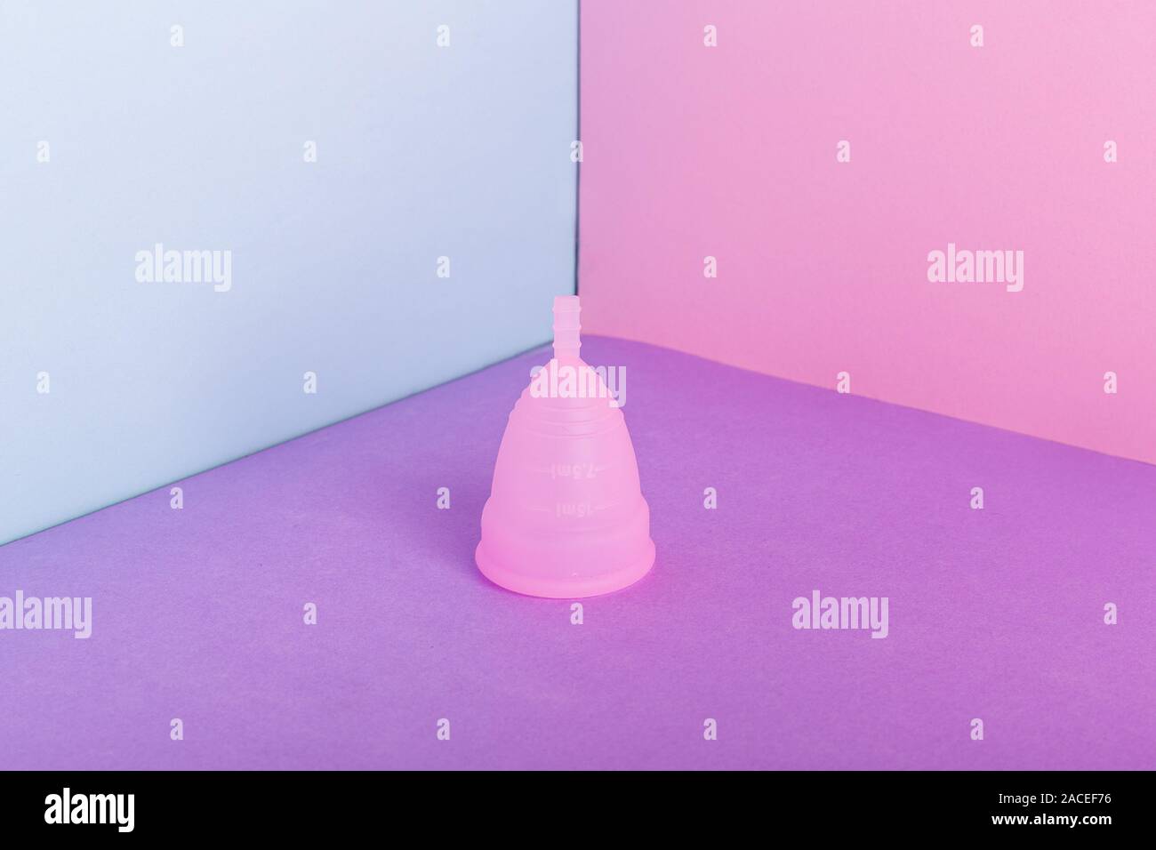Pink reusable menstrual cup on color background. Woman critical days ...
