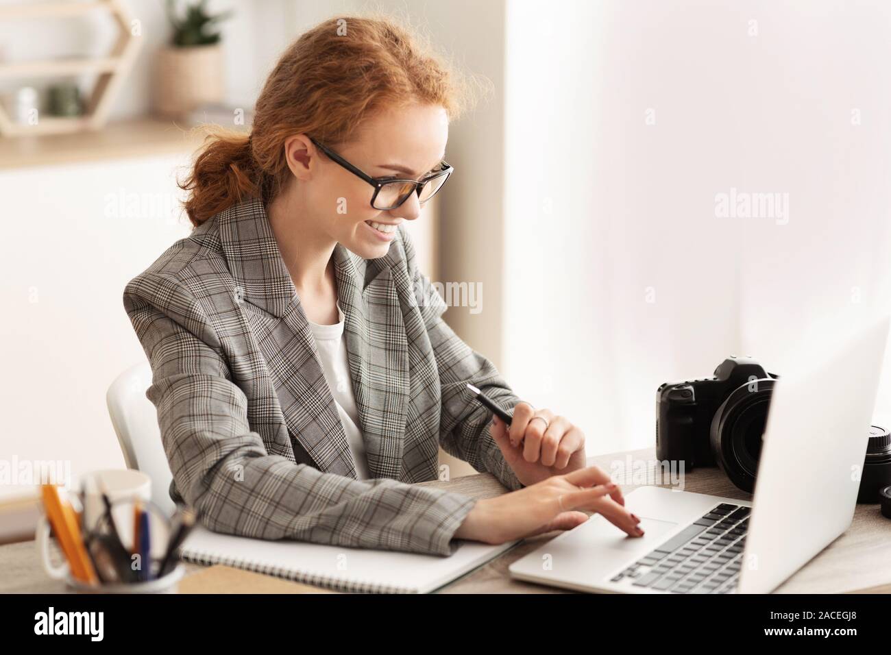Woman reporter working with laptop and camera Stock Photo - Alamy