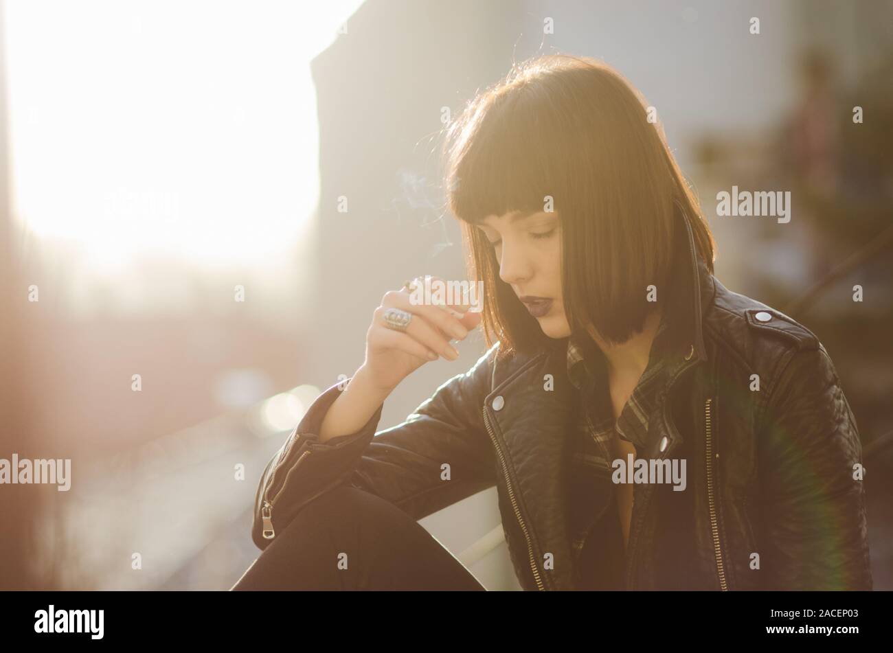 Portrait of a young woman with rock jacket smoking cigarette Stock ...