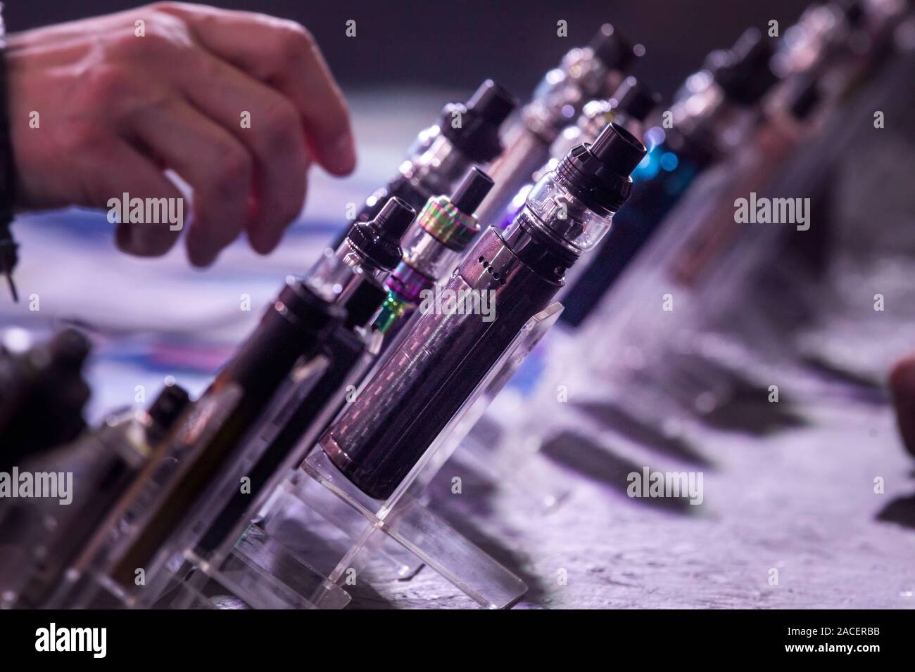 A man chooses a device from the range of electronic cigarettes and vape ...