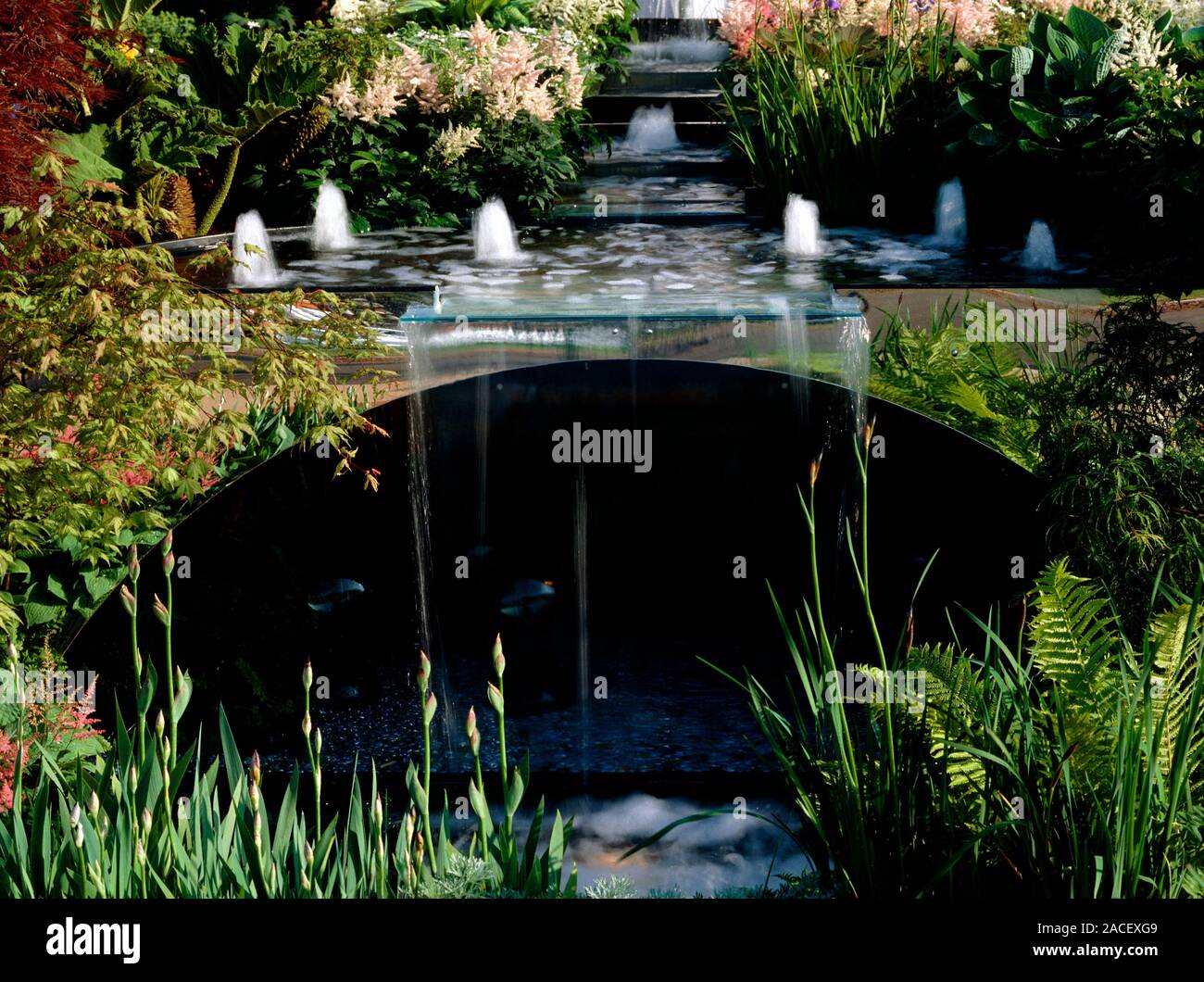 Glass water feature. Water from a fountain cascading over a glass ledge ...