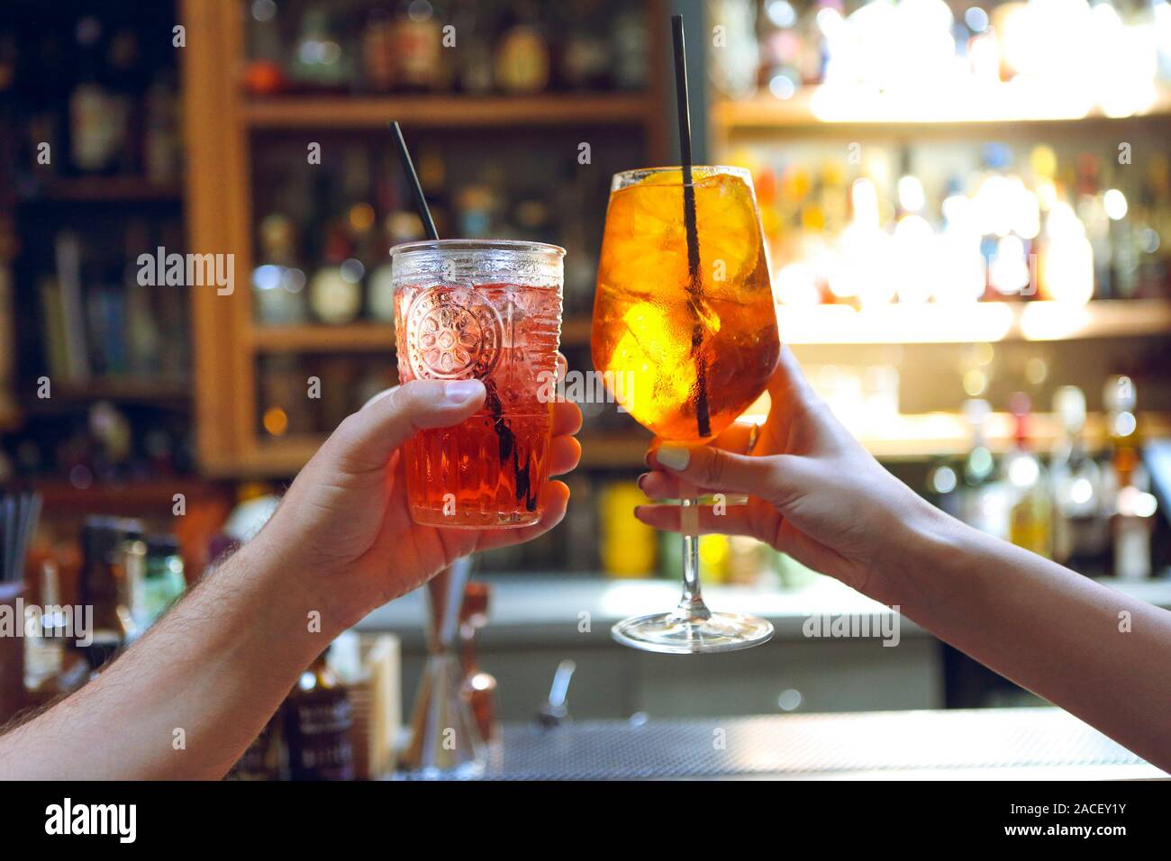 Woman and man raising a glasses of coktails in the bar background Stock ...