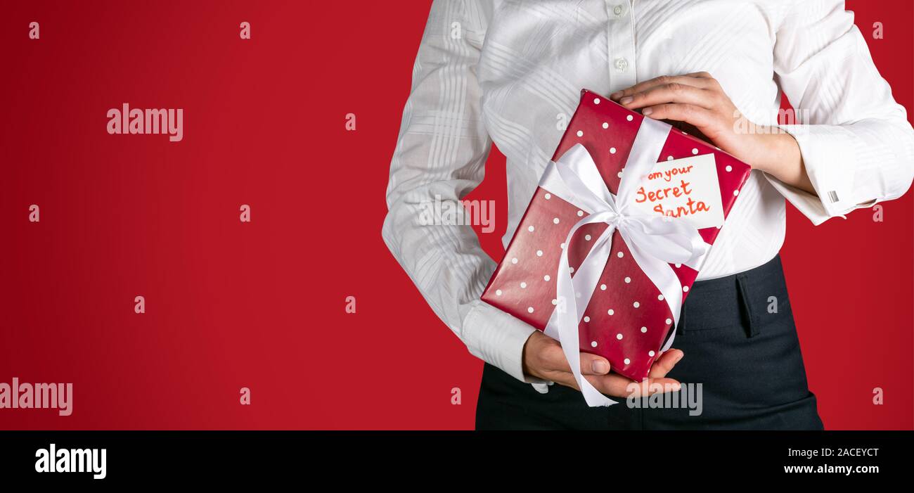 Secret Santa concept - female in office clothes holding wrapped present ...