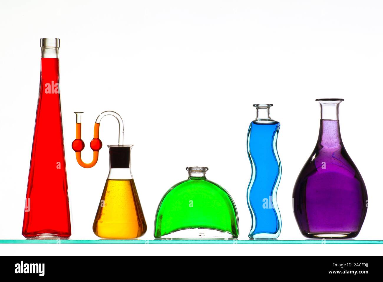 Coloured liquids in five different shaped bottles. This shows how ...