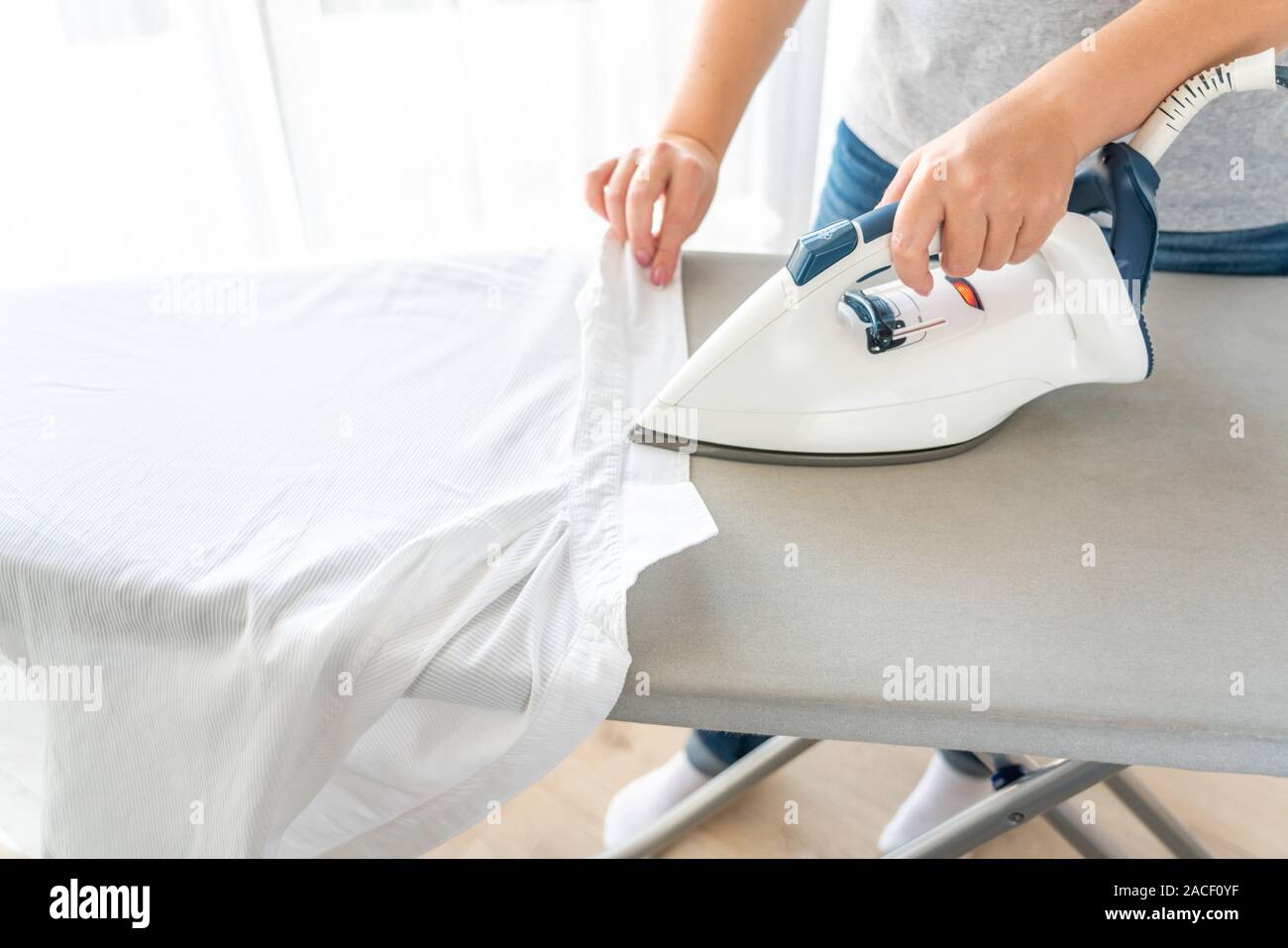 Close up of Female hands ironing white shirt on ironing board Stock ...