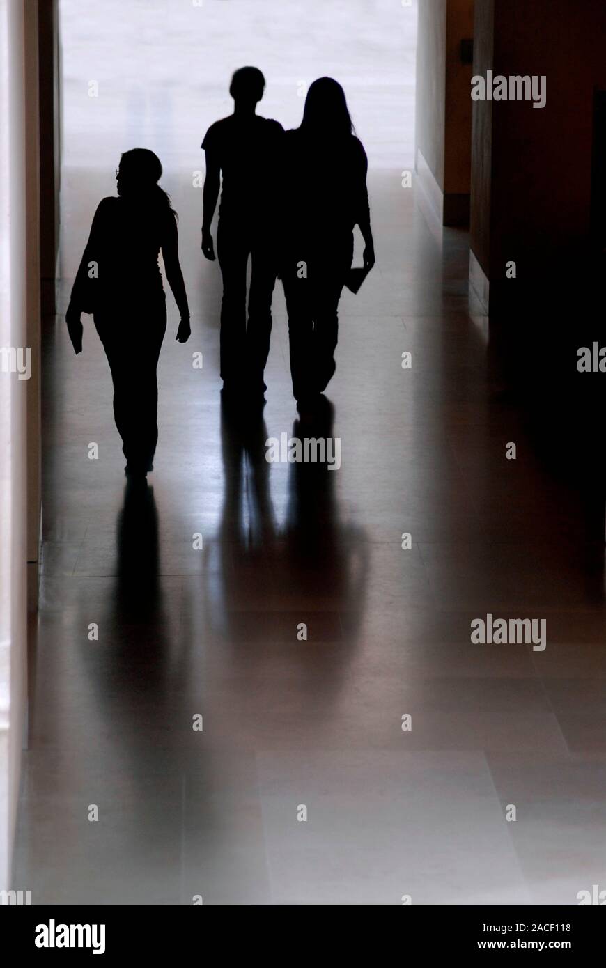People in a corridor. Three people walking down a corridor Stock Photo ...