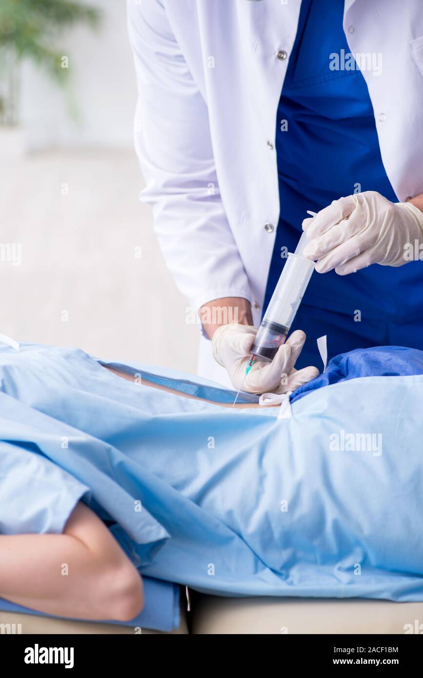 The female patient getting an injection in the clinic Stock Photo - Alamy