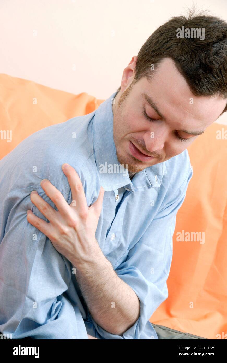 Shoulder pain. Man holding his painful shoulder. The shoulder is an ...
