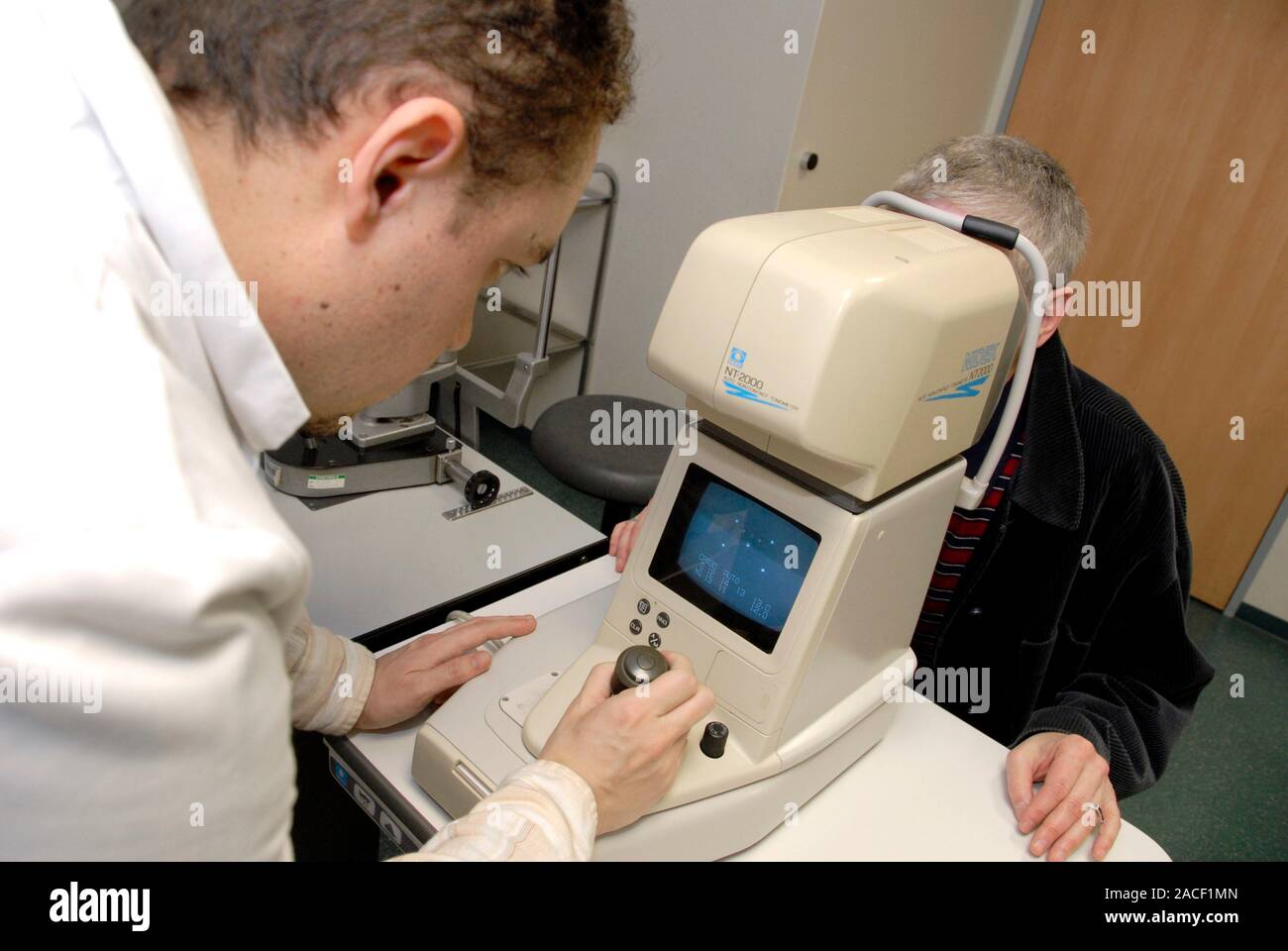 Emergency eye examination. Doctor using an automated non-contact ...