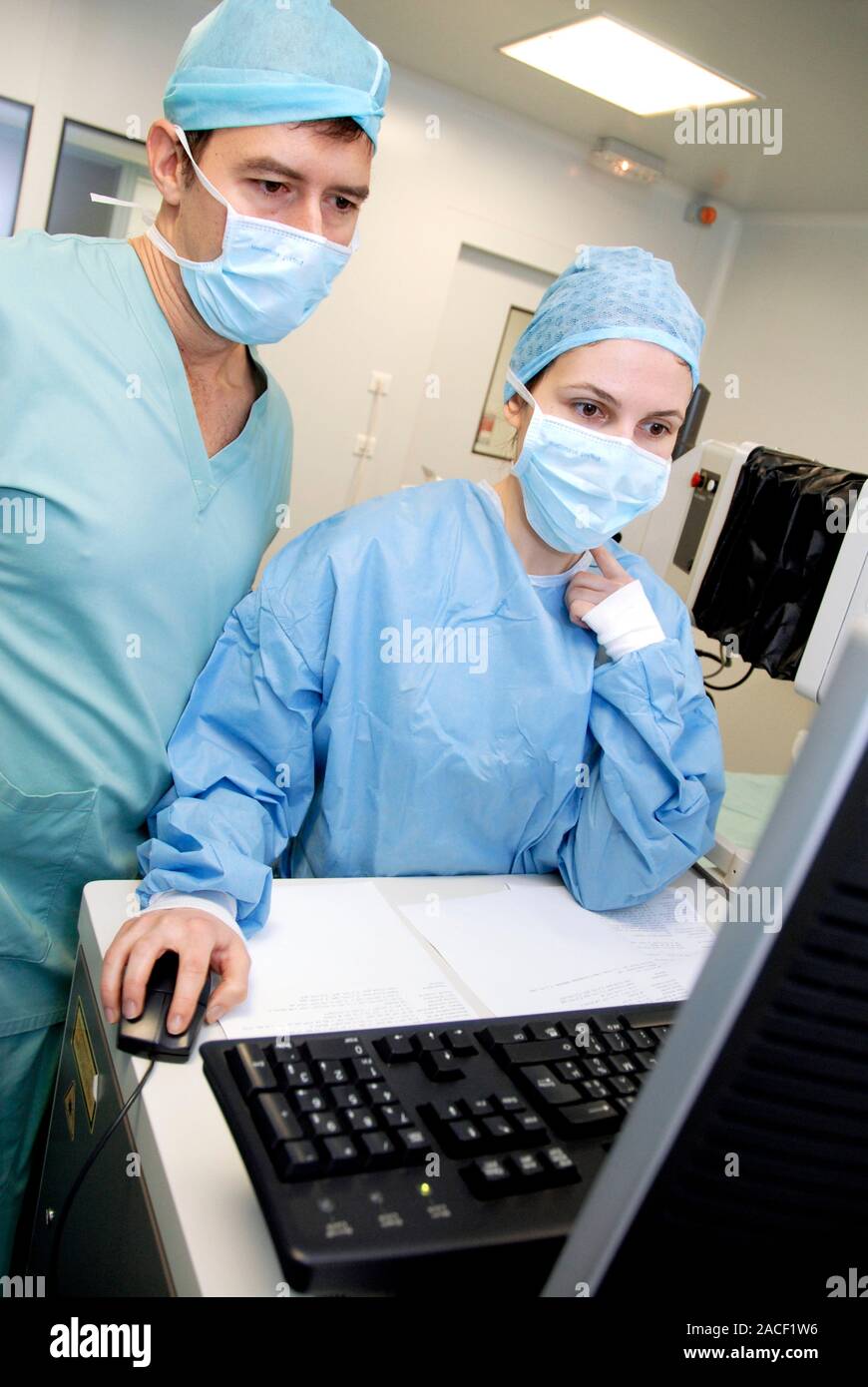 Laser eye surgery. Surgeons using a computer as they carry out excimer ...