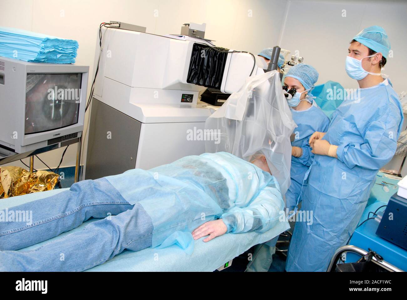 Laser eye surgery. Surgeons carrying out excimer laser refractive ...