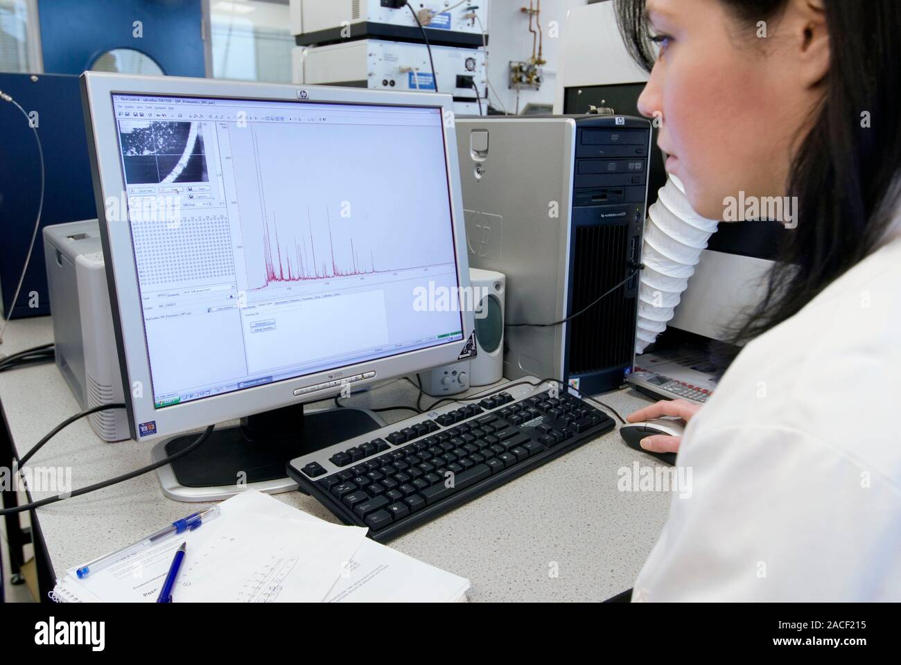 Mass spectrometry. Researcher analysing results from a mass spectrometer experiment to determine ...
