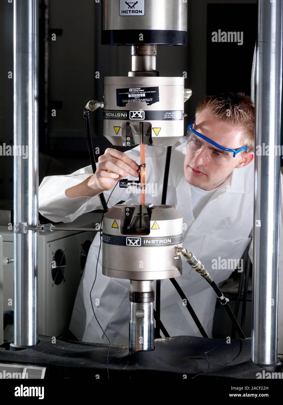 Materials testing. Technician testing an object in a typical mechanical ...