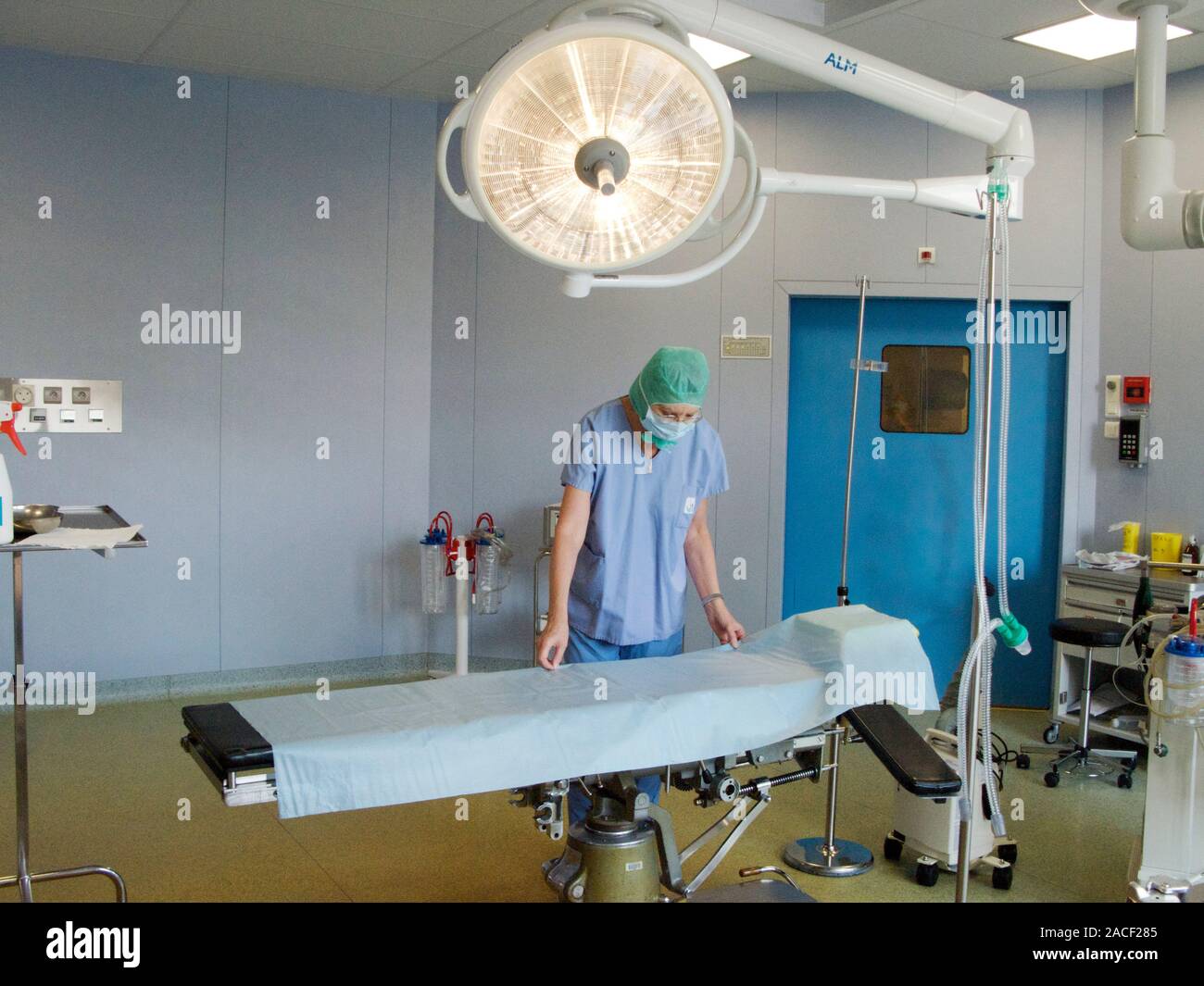 Operating theatre. Theatre assistant preparing an operating table for ...