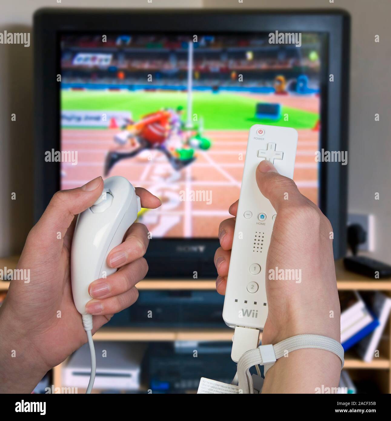 Nintendo Wii. Player using a wireless controller (right) and a nunchuck ...