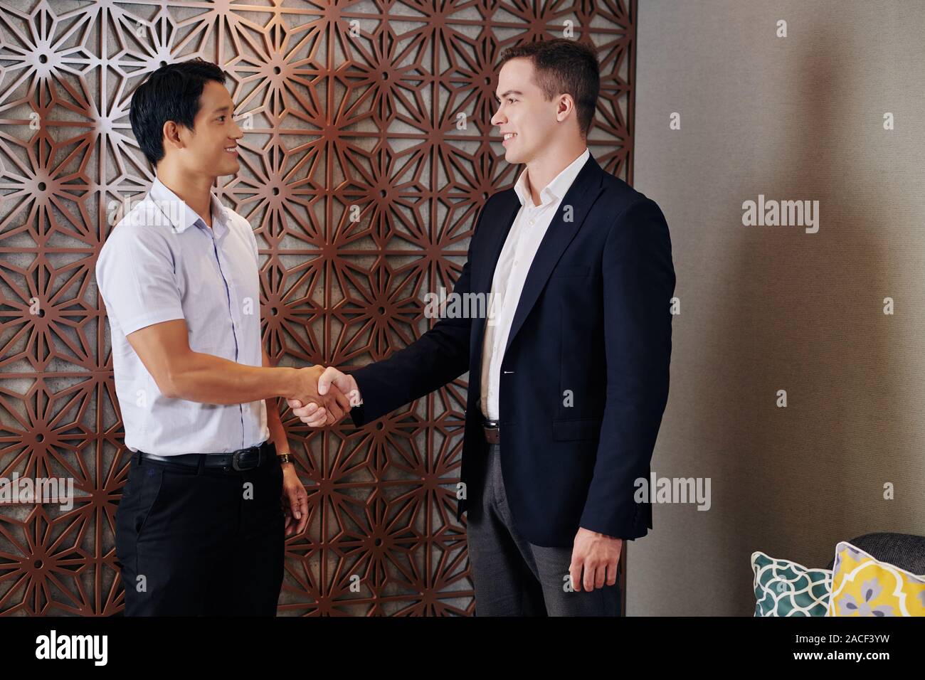 Standing leadership smiling greeting shaking hands hi-res stock ...