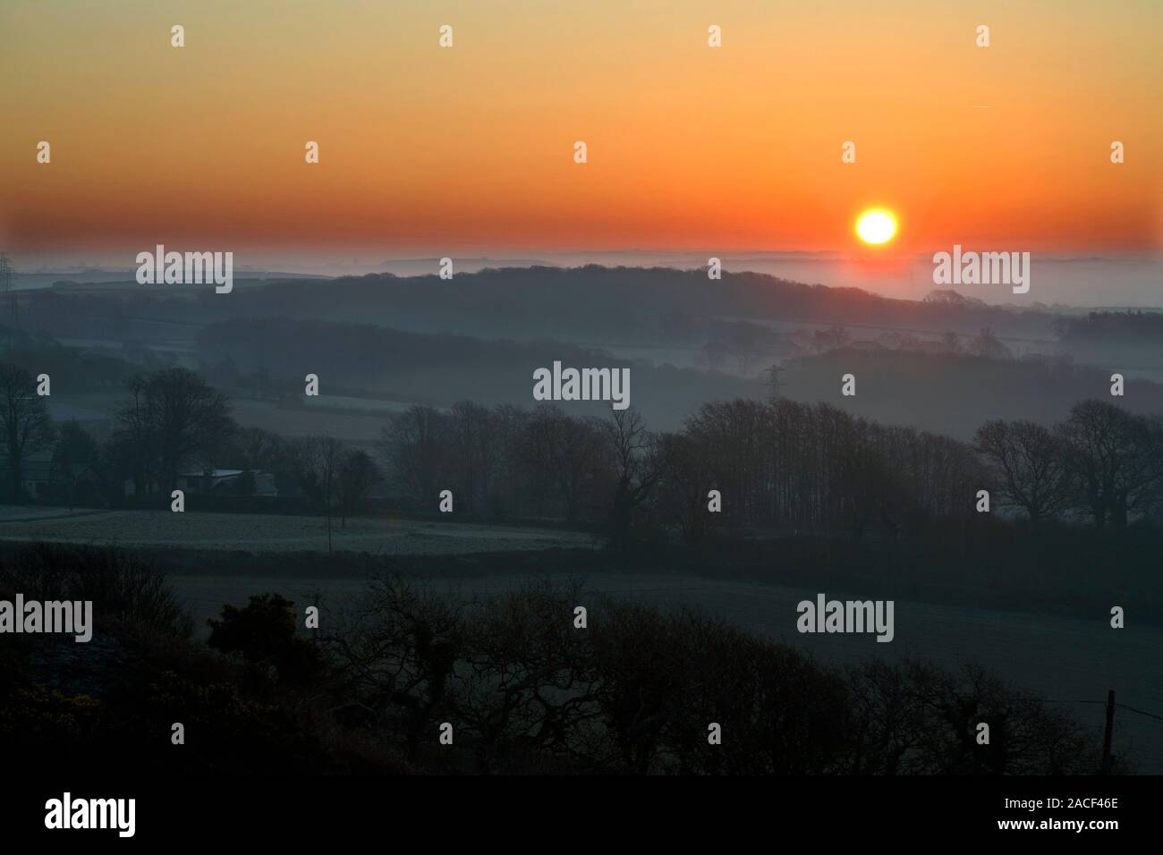 Morning mist. Sun rising over a misty valley. Photographed at Codden ...