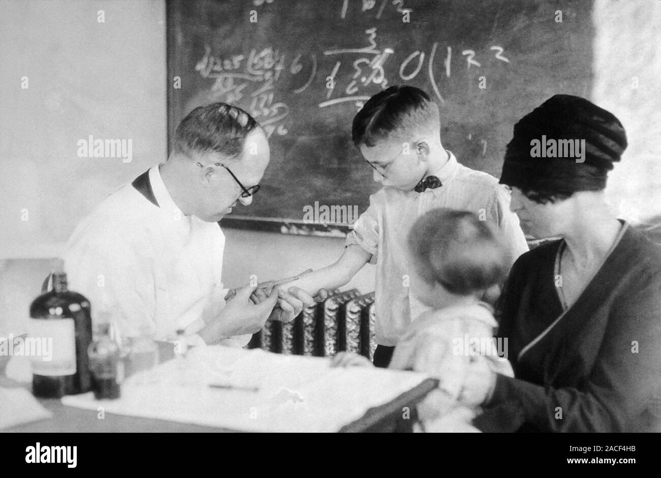 Schick test. Doctor performing a Schick test on a young patient. This ...