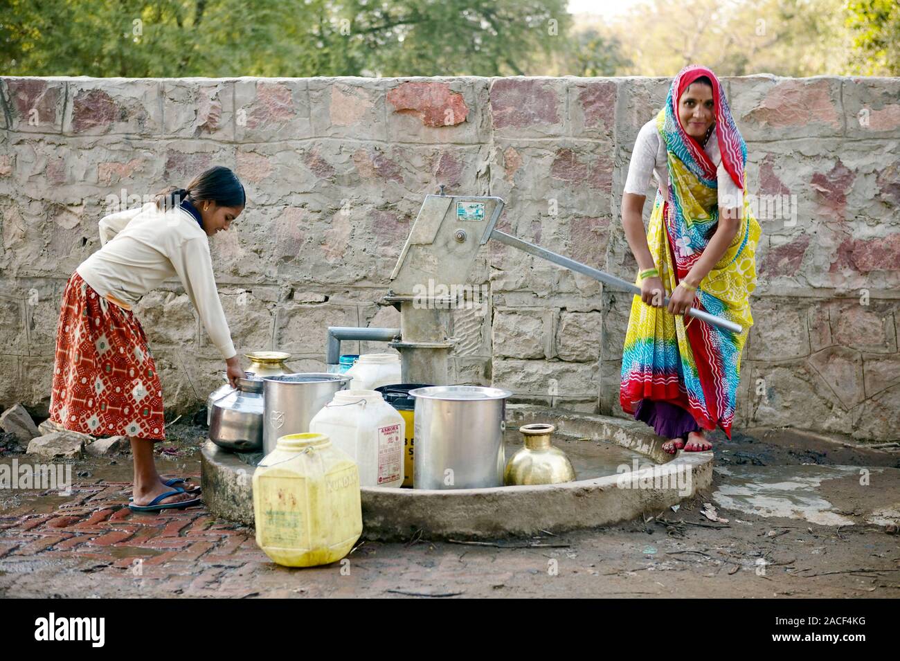 Water well. Woman and child collecting drinking water from a well ...