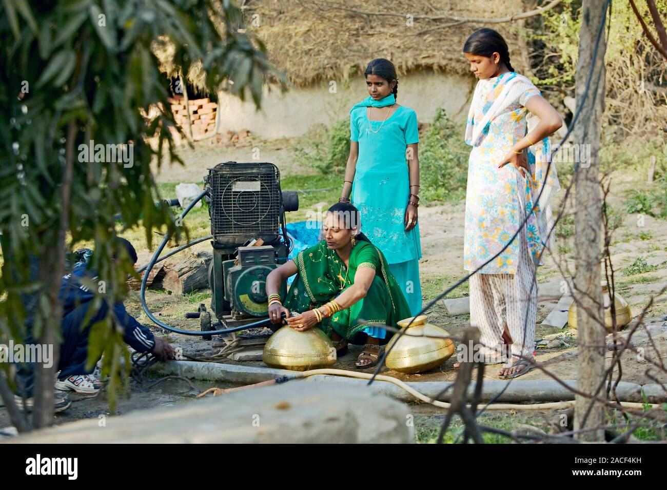 Water well. Woman and children collecting drinking water from a well ...
