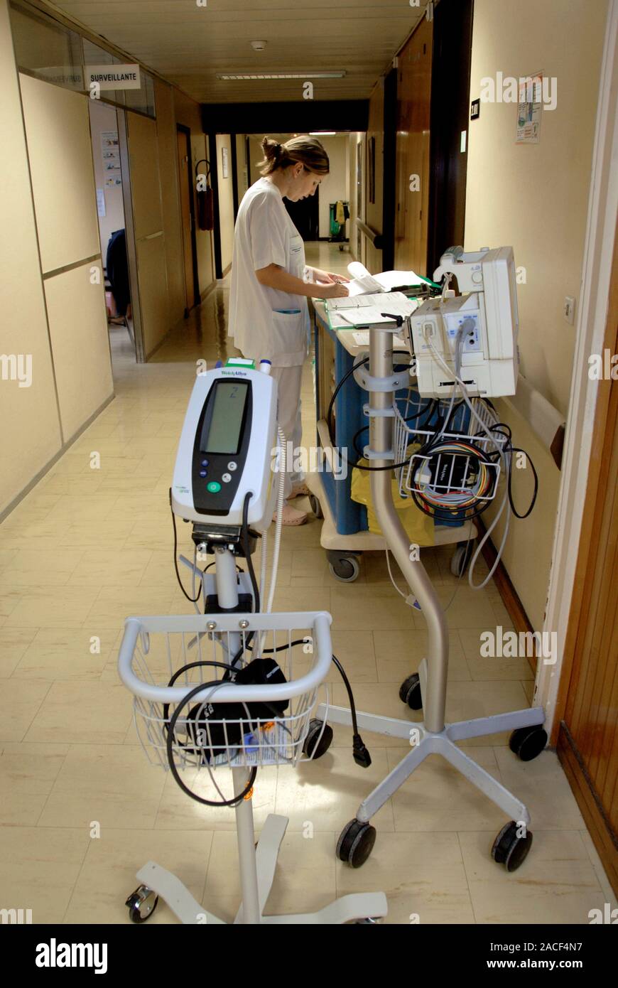 Nurse and hospital equipment. Nurse making notes on a trolley in a ...