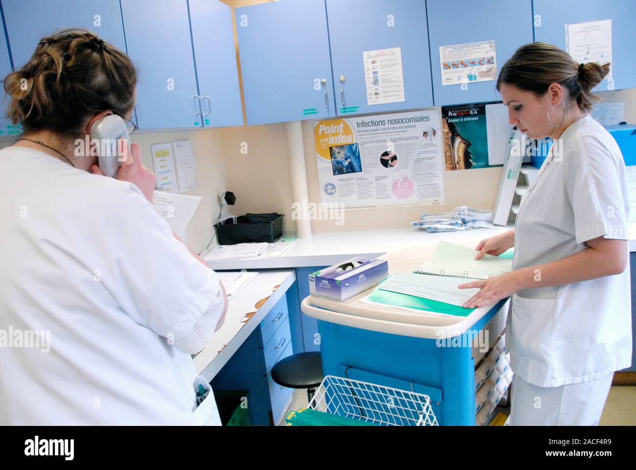 Nurse workstation. Hospital nurses at their workstation, consulting ...