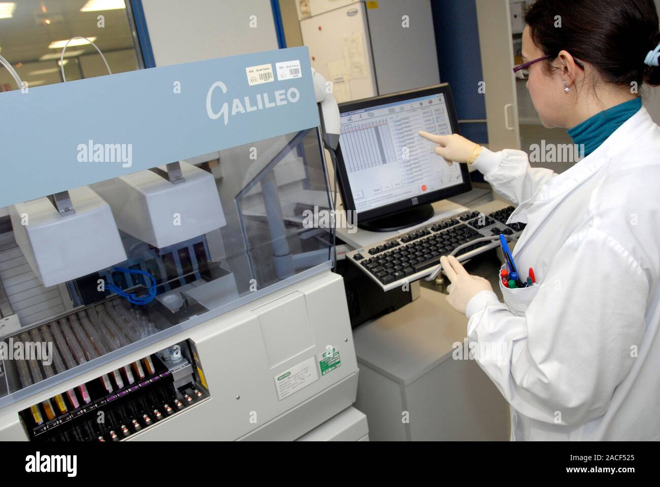 Blood analysis. Haematologist preparing a blood typing machine, which ...