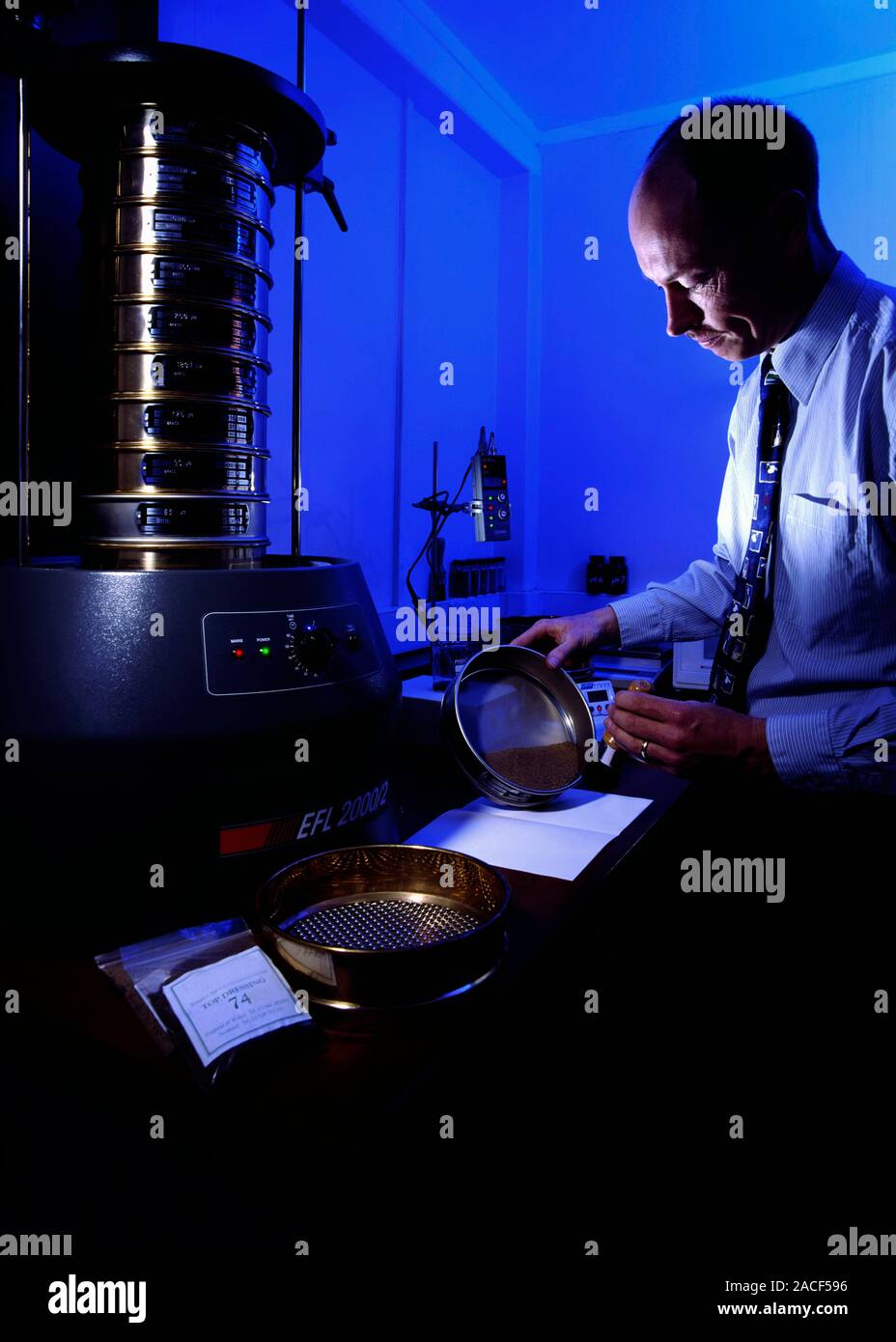 Testing soil samples. Scientist using a soils sample grader (upper left ...