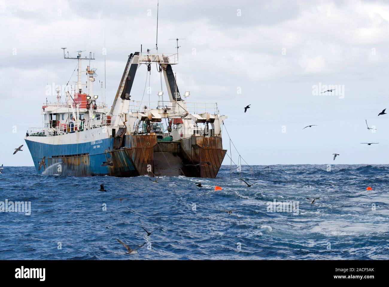 Fishing boat trawling for fish. Trawling is a method of fishing that ...