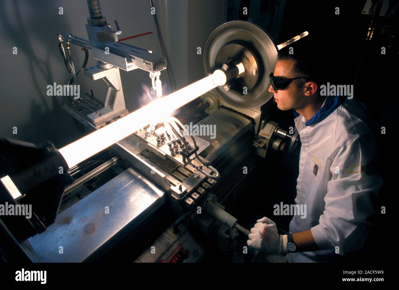 Fibre optics manufacturing. Two glass rods (called 'preforms') being ...