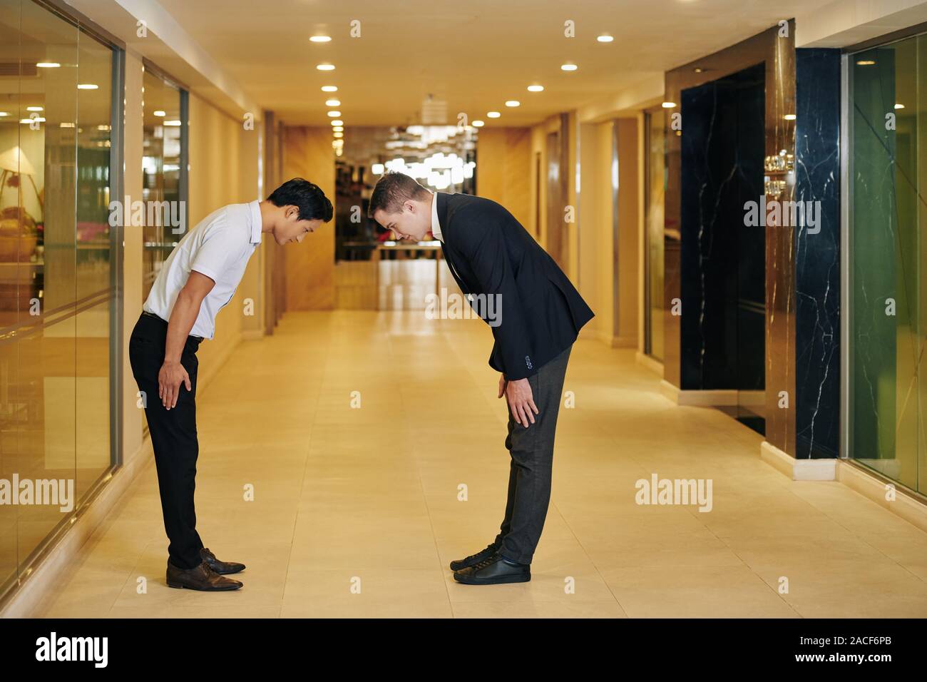 Multi-ethnic business colleagues bending forward to express respect and ... Multi-ethnic business colleagues bending forward to express respect and ...