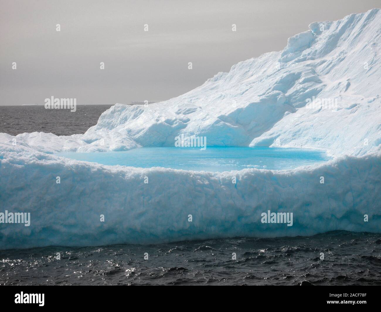 Antarctic iceberg. Pool of meltwater that has formed on an iceberg in Antarctic waters. Icebergs ...