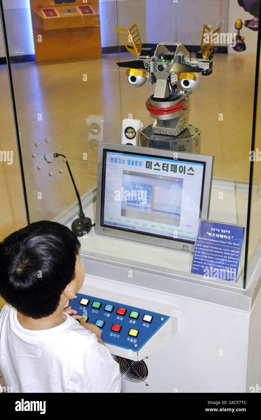 Mr Face robot and child. Boy interacting with the Mr Face robot. This ...
