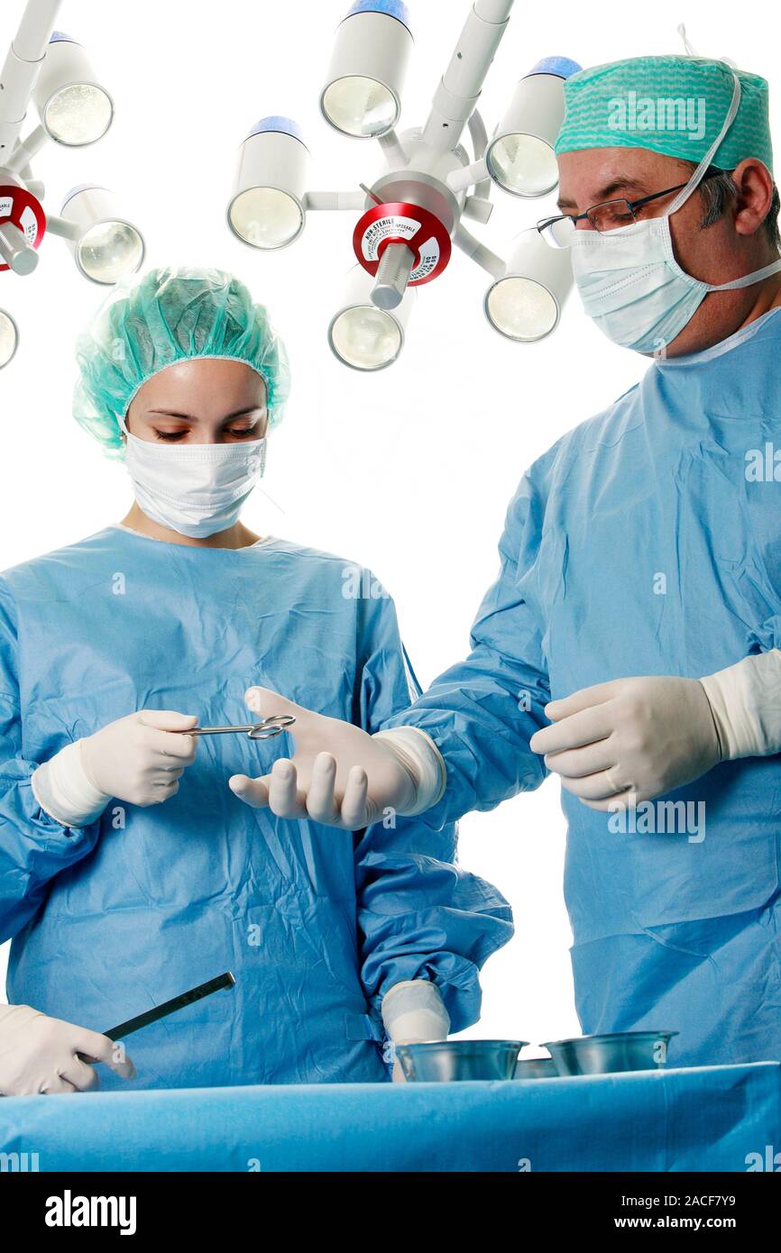 Surgery. Surgical assistant passing forceps to a surgeon during an ...