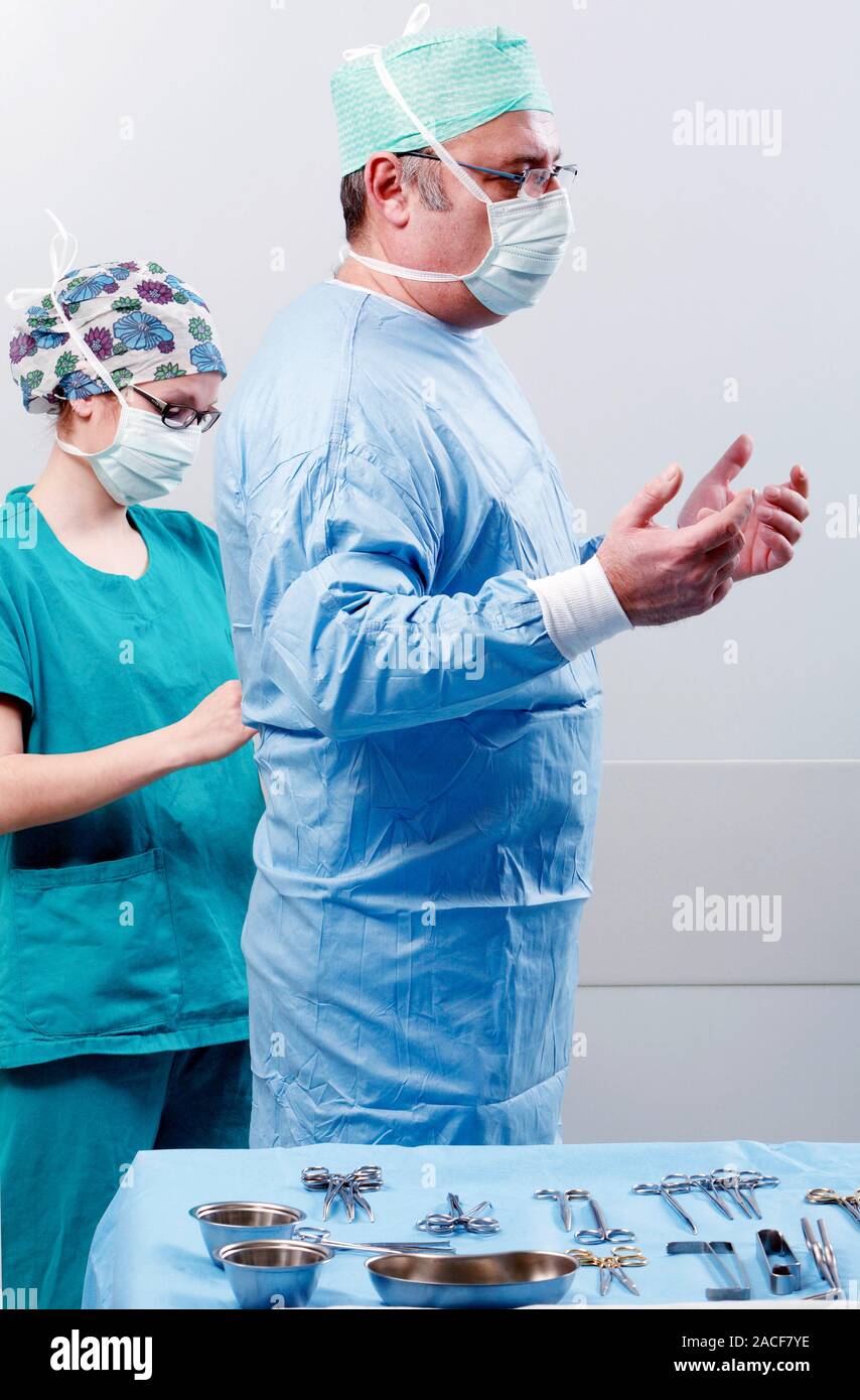 Surgeon being assisted in dressing for an operation Stock Photo - Alamy